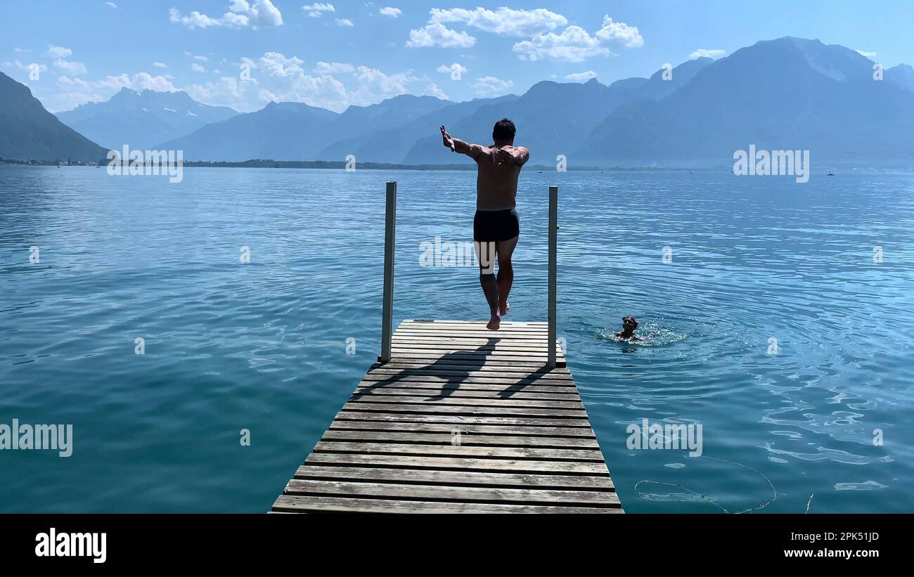 Man running in lake pier and diving into water Stock Photo - Alamy