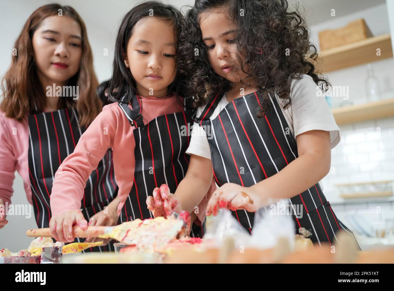 Child making cake with family, Family having fun together in kitchen ...