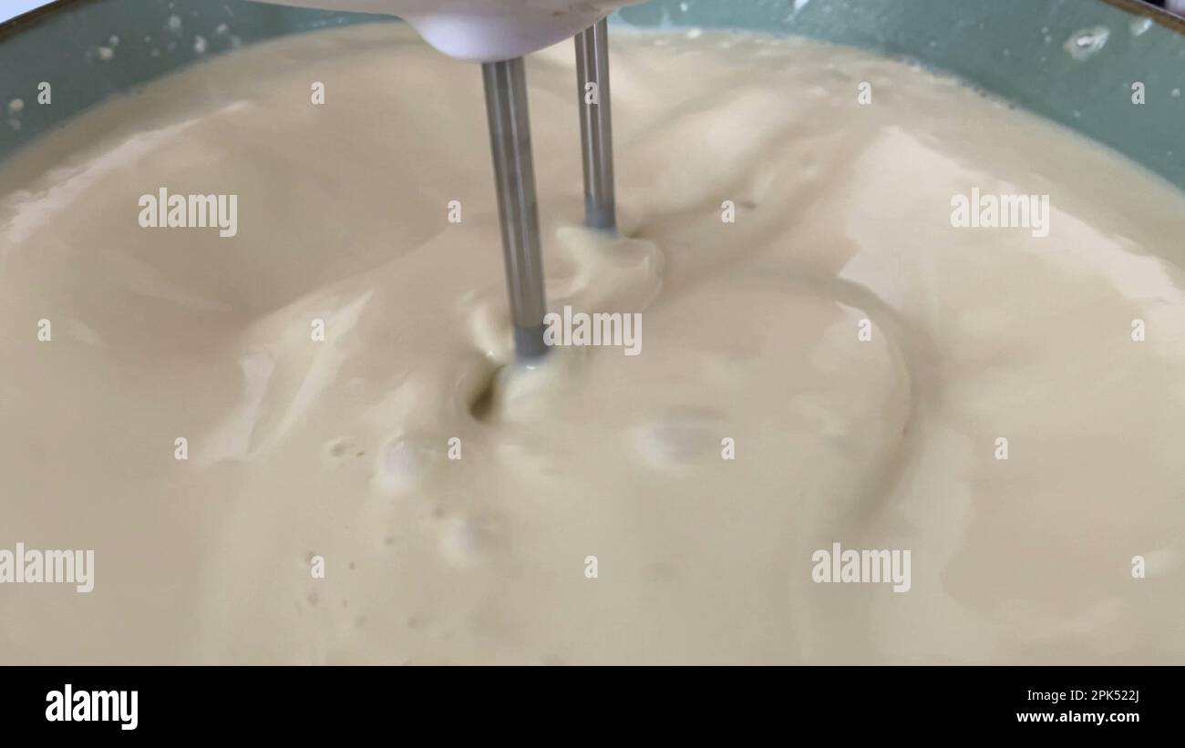 Mixing cream in mixing machine, dough in electric mixer Stock Photo - Alamy