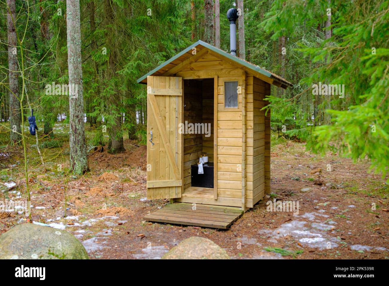Wooden outdoor toilet in the forest with an open door. toilet paper ...