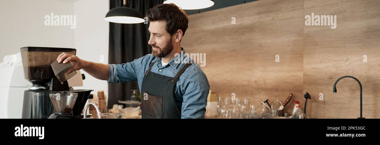 Barista grinds coffee beans before making coffee Stock Photo - Alamy