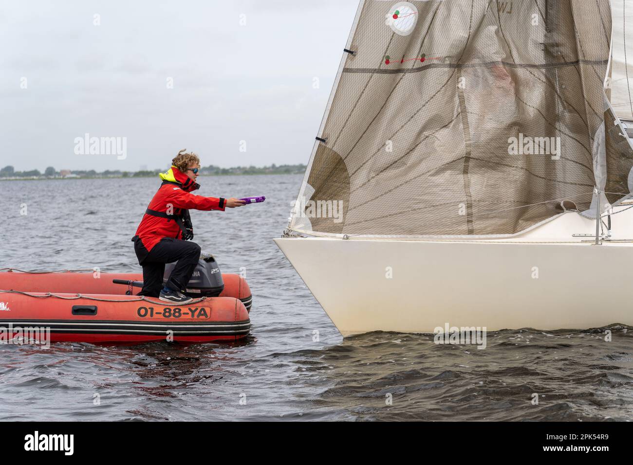 A Caucasian adult is floating in a raft handing a purple item Stock ...
