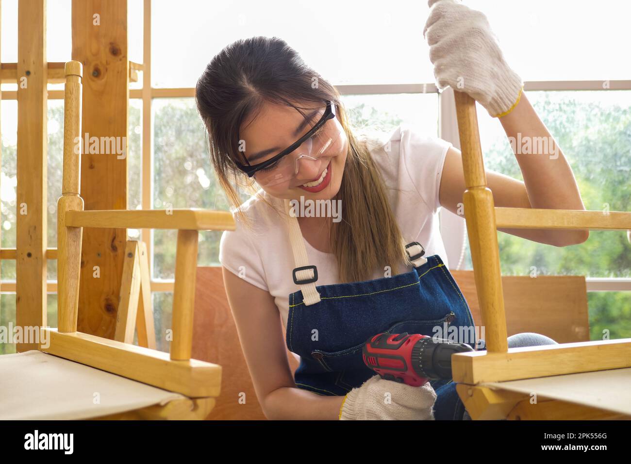 Portrait of professional female carpenter worker using electrical ...