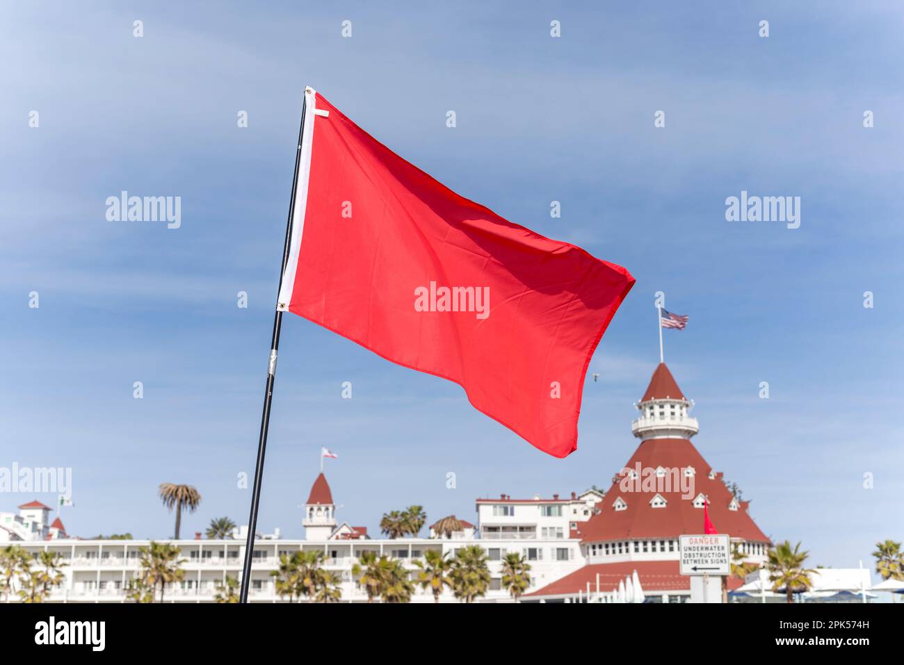Red flag on Coronado Central Beach with the Hotel Del Coronado in the ...