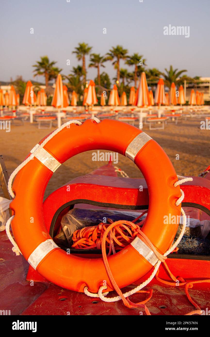 lifebuoy and sunbeds at empty sandy castello beach during sunrise at ...