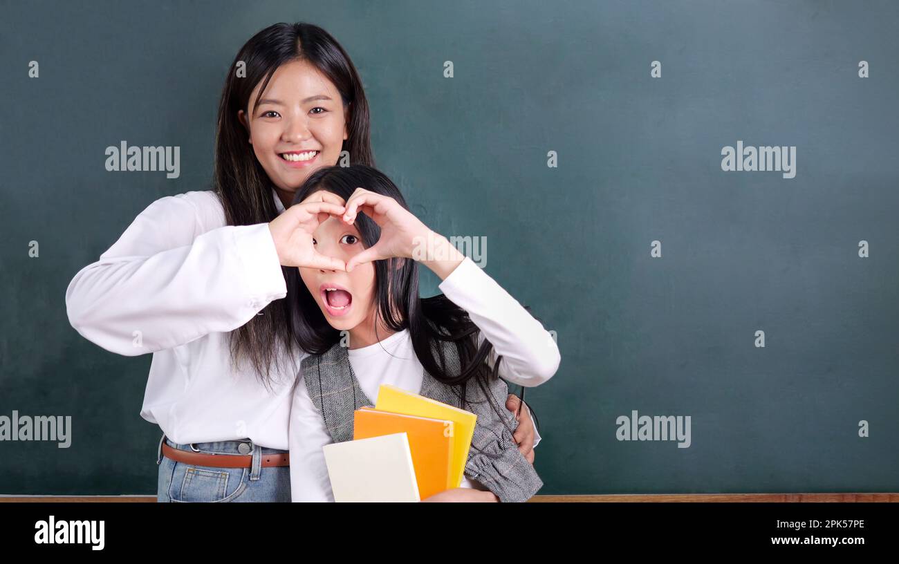 Happy student studying with teacher in classroom at school Stock Photo ...