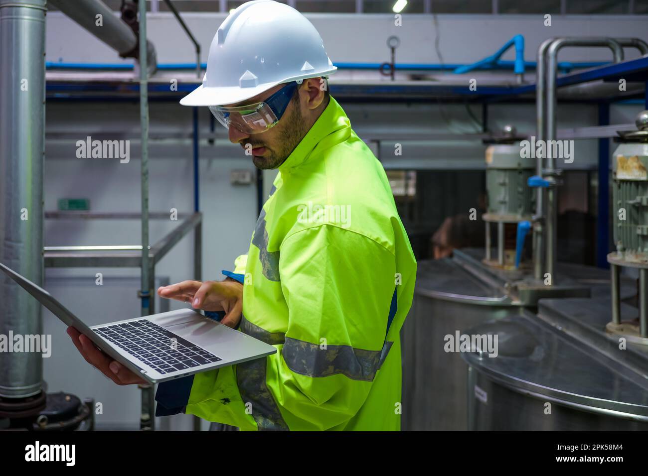 Engineer specialist using laptop checking and maintaining machine in ...