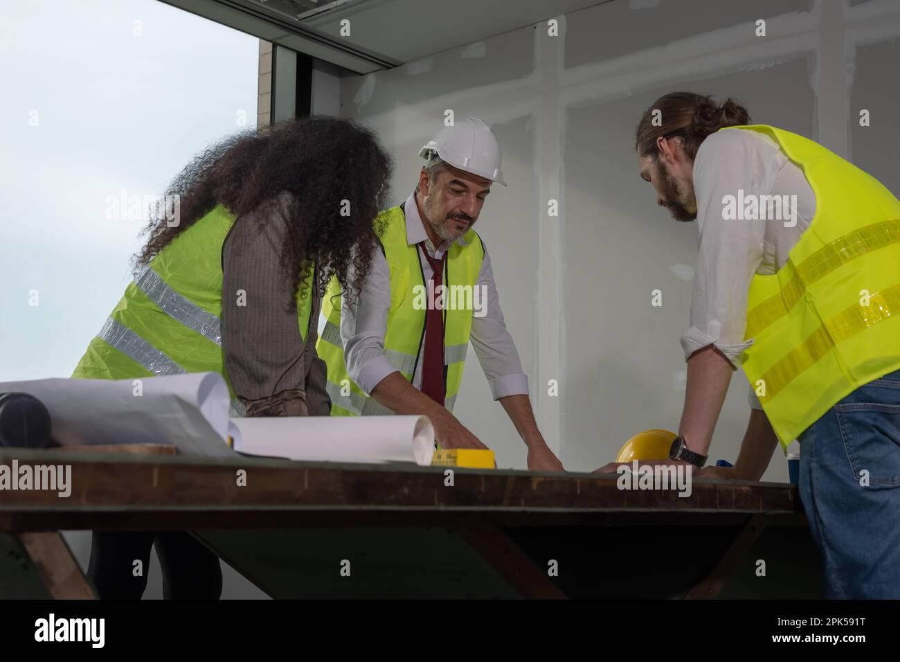 Professional construction engineers team using blueprint of project ...