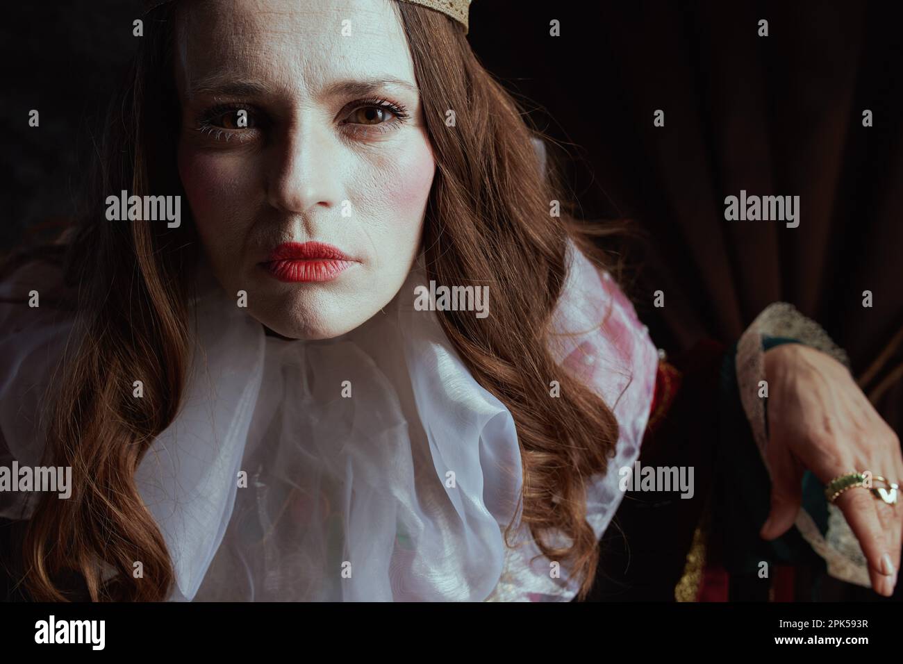 scary medieval queen in red dress with white collar on dark gray ...