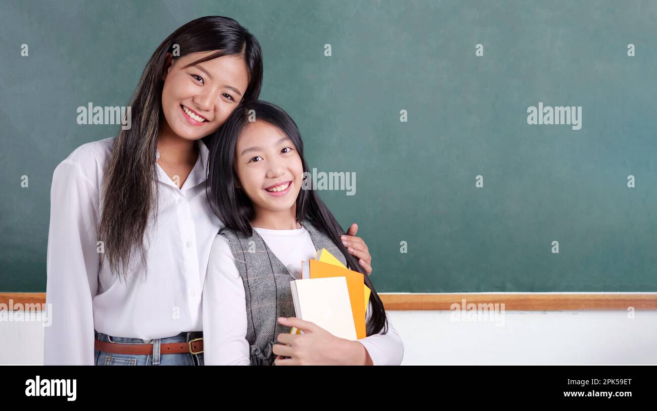 Happy student studying with teacher in classroom at school Stock Photo ...