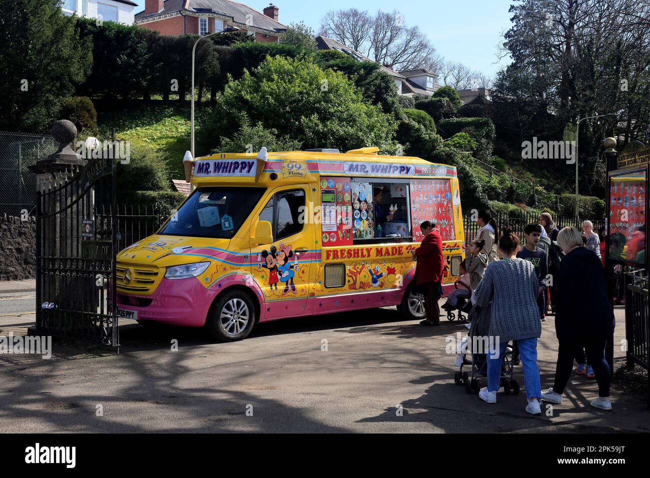 Mr Whippy yellow ice cream van with queue of people, Roath Park ...