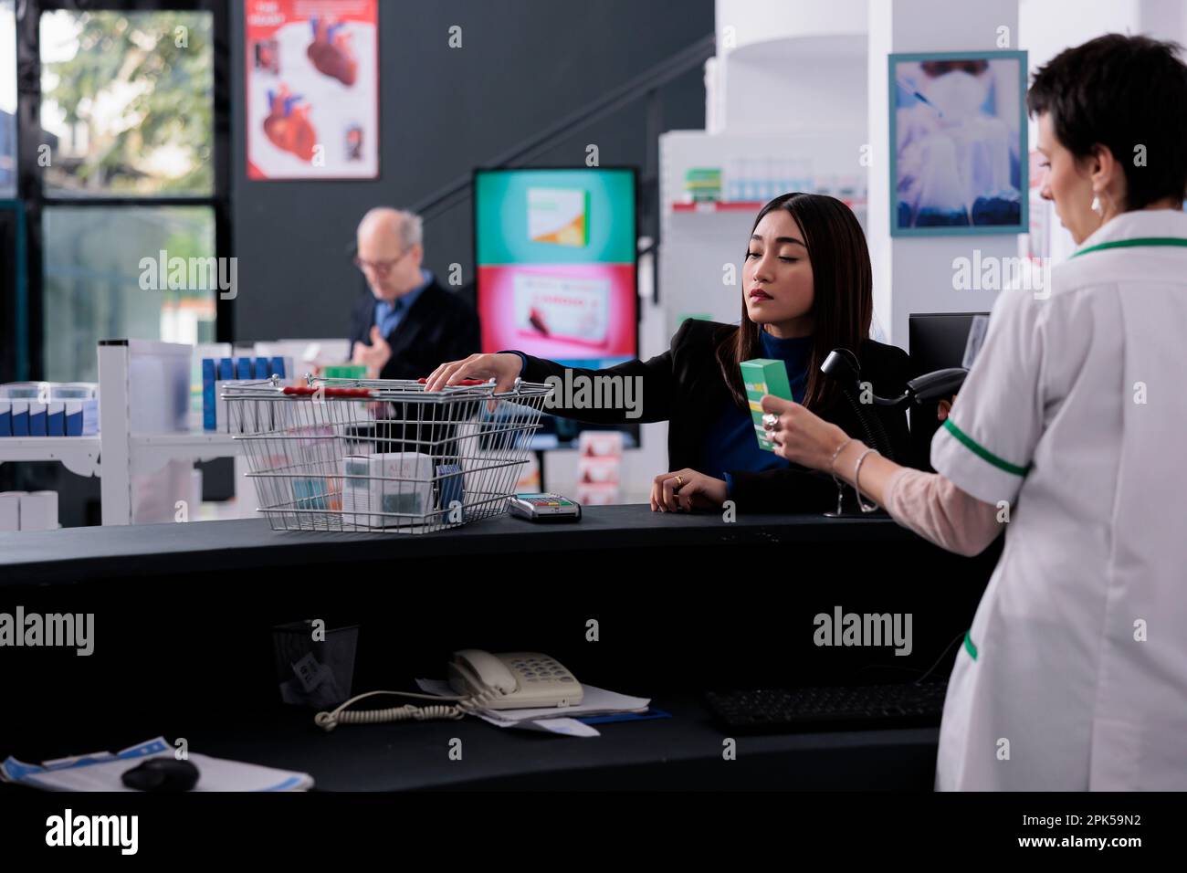 Pharmacy buyer giving cashier medications for scanning at drugstore ...
