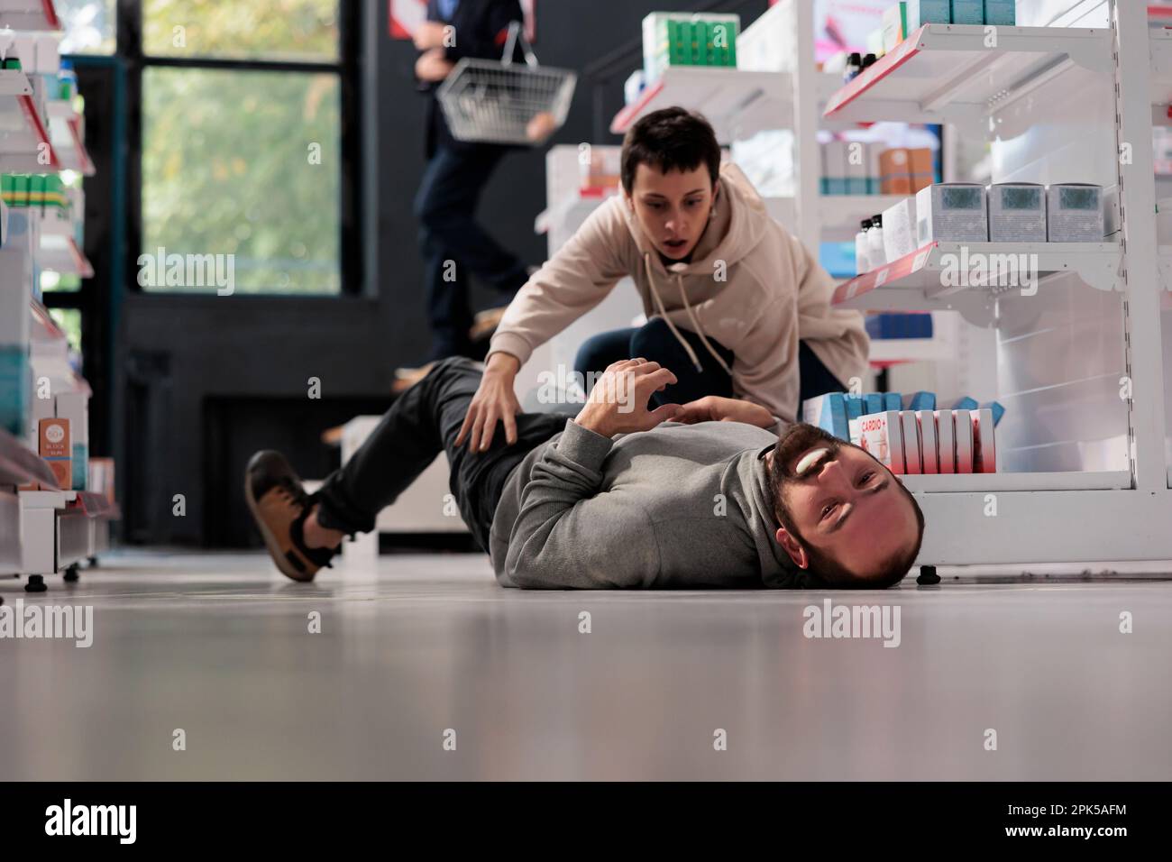 Terrified woman noticing man on drugstore floor having epileptic ...