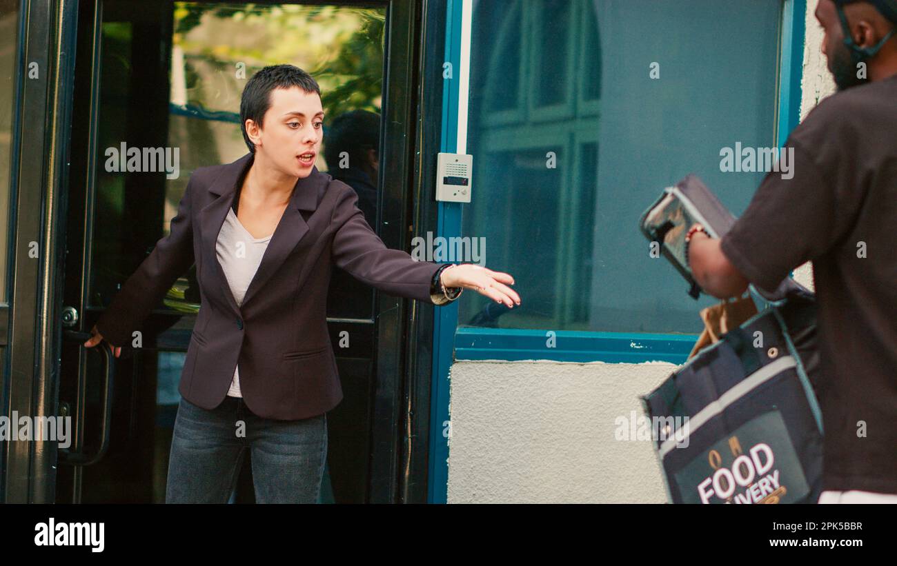 Angry woman shouting at food delivery employee, yelling about problem ...