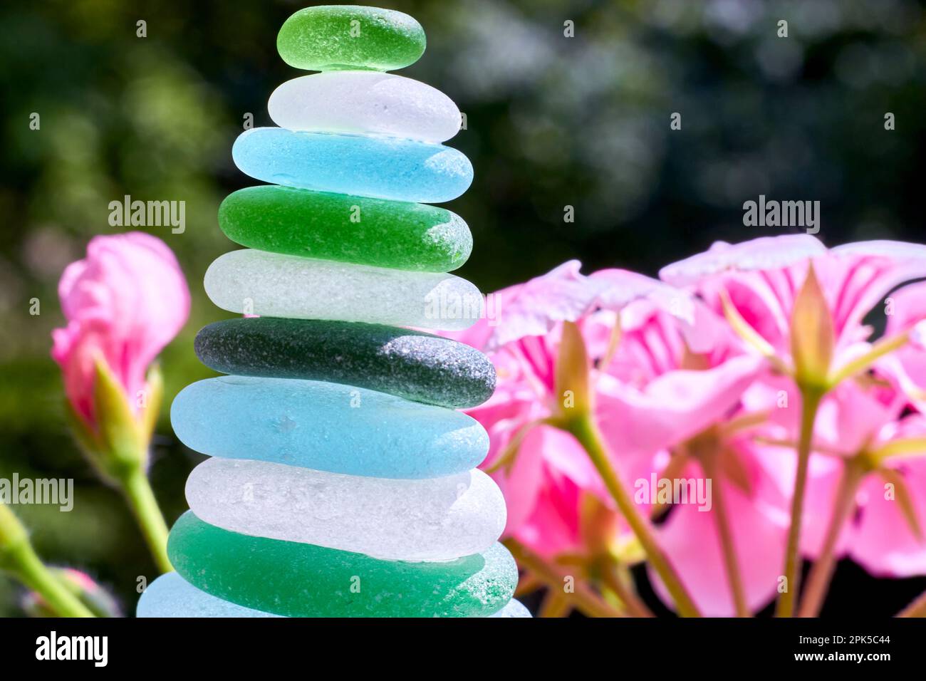 Zen pyramid of glass sea stones from the beach on a background of red ...
