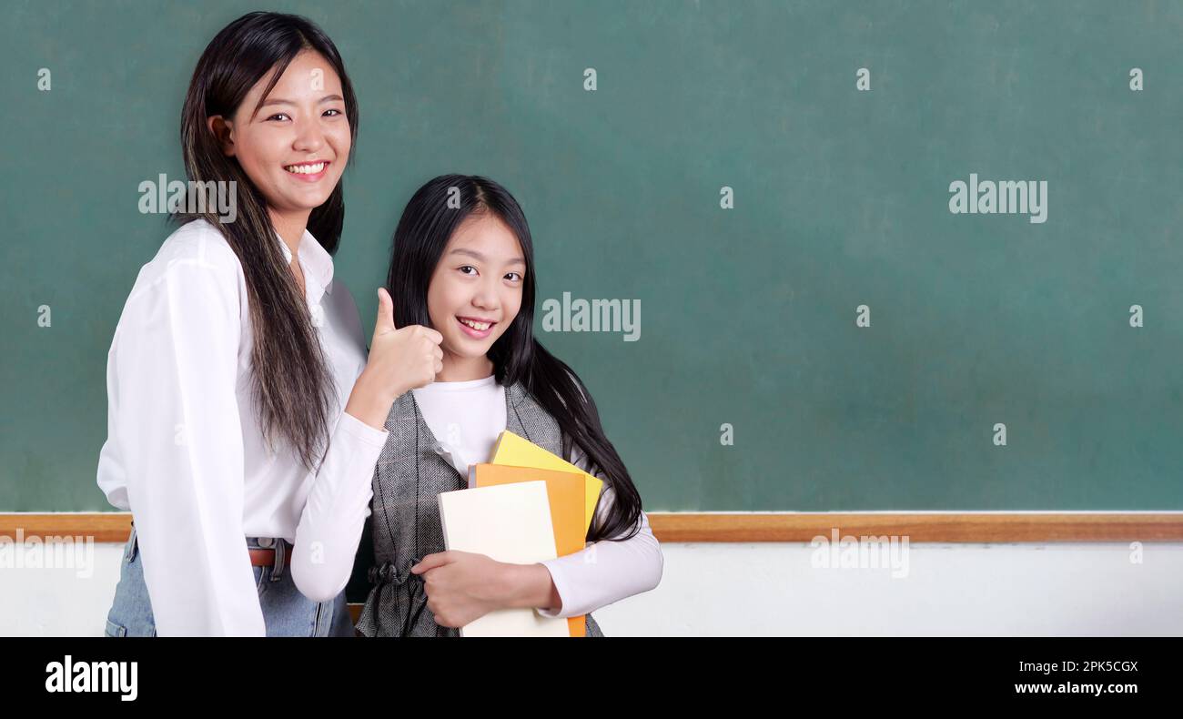 Happy student studying with teacher in classroom at school Stock Photo ...