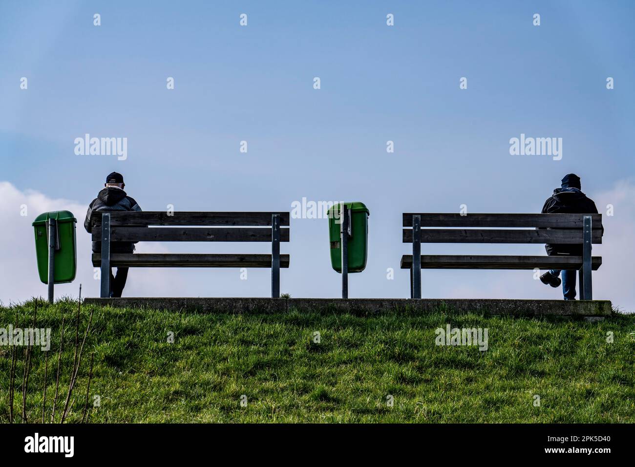 Benches on a dyke on the Weser in Bremerhaven, two people sitting ...