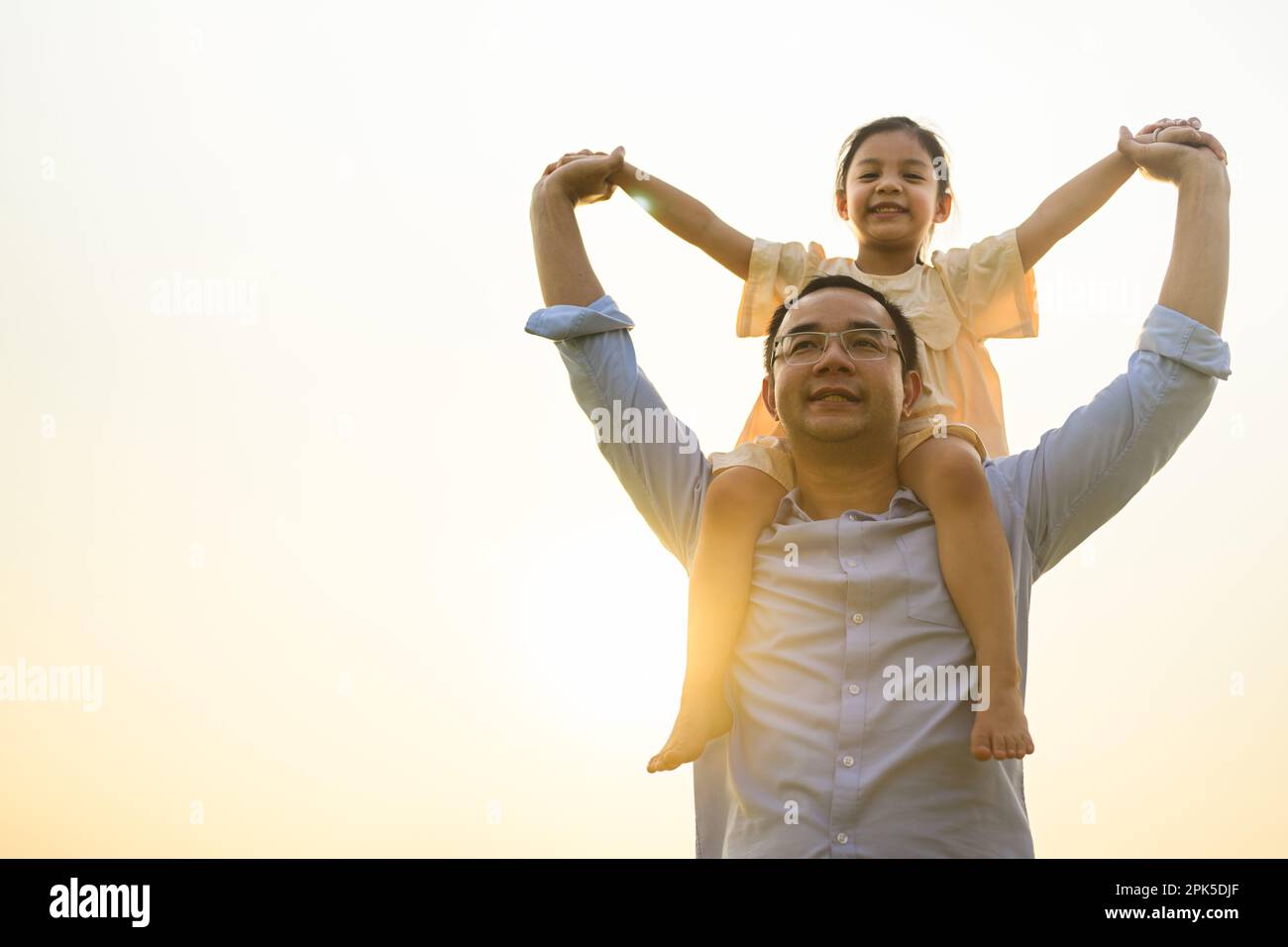Happy father giving daughter piggyback on shoulder with sunset view Stock Photo - Alamy