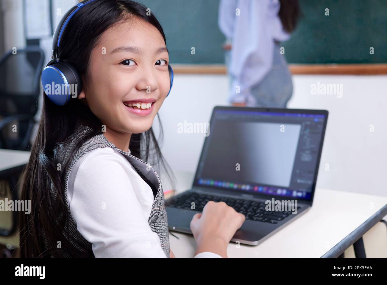 Happy student studying with teacher in classroom at school Stock Photo - Alamy