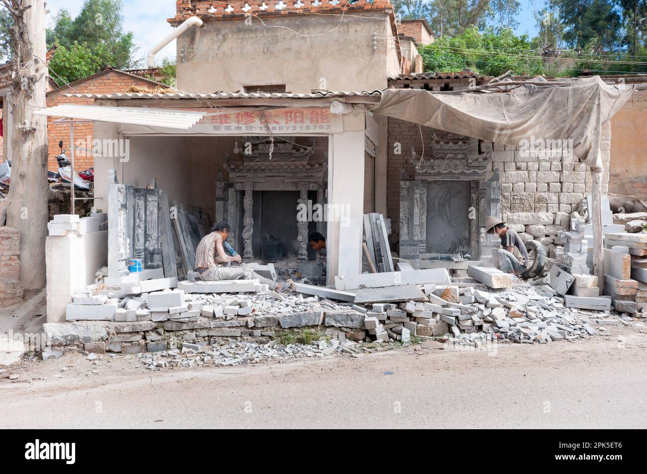 Chinese stone masons working on carving their intricate designs at a ...