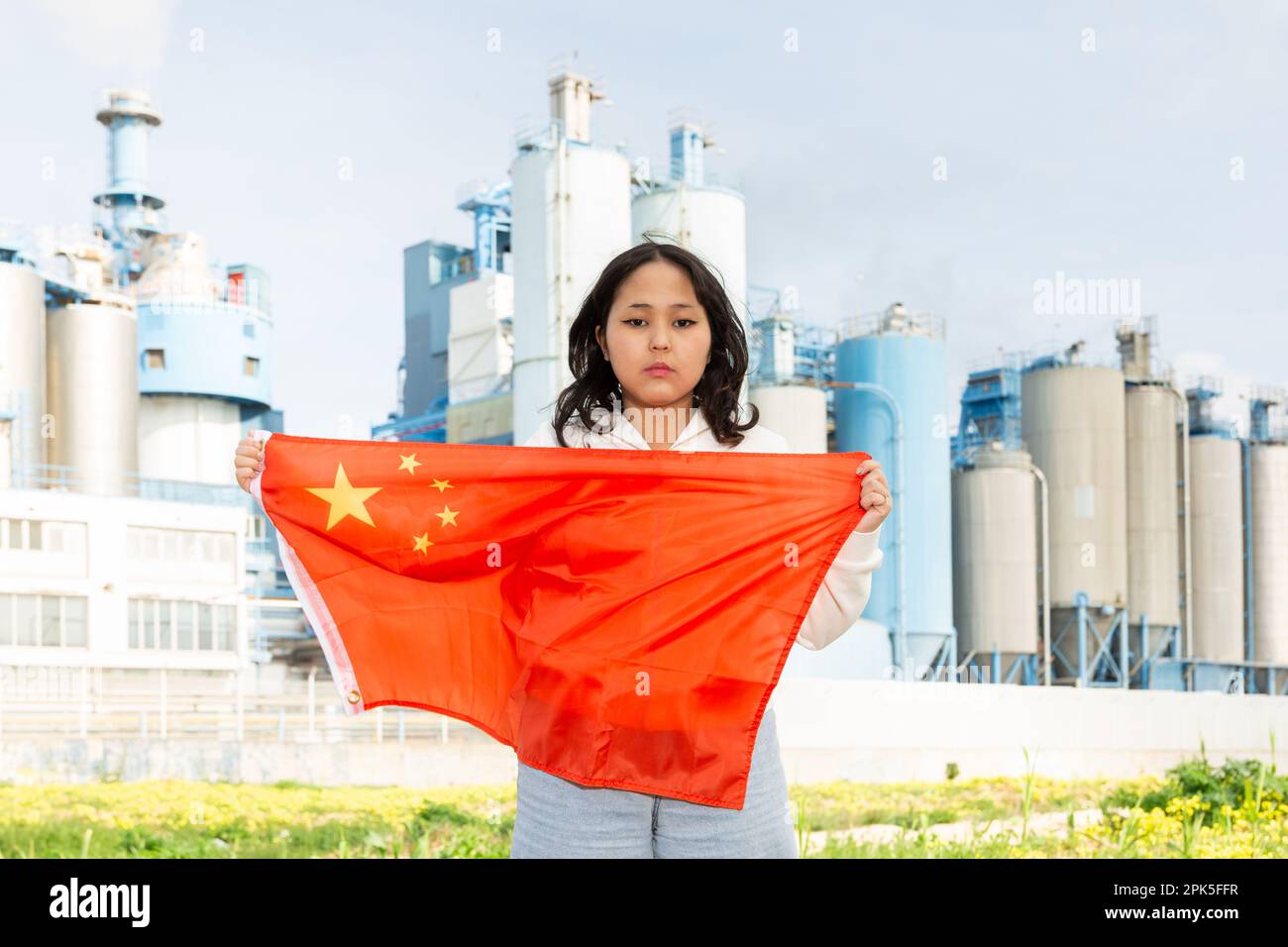 Sad young woman with flag of China against background of factory Stock ...