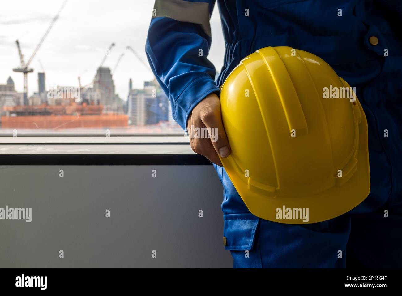 Engineer holding yellow helmet with construction building site ...