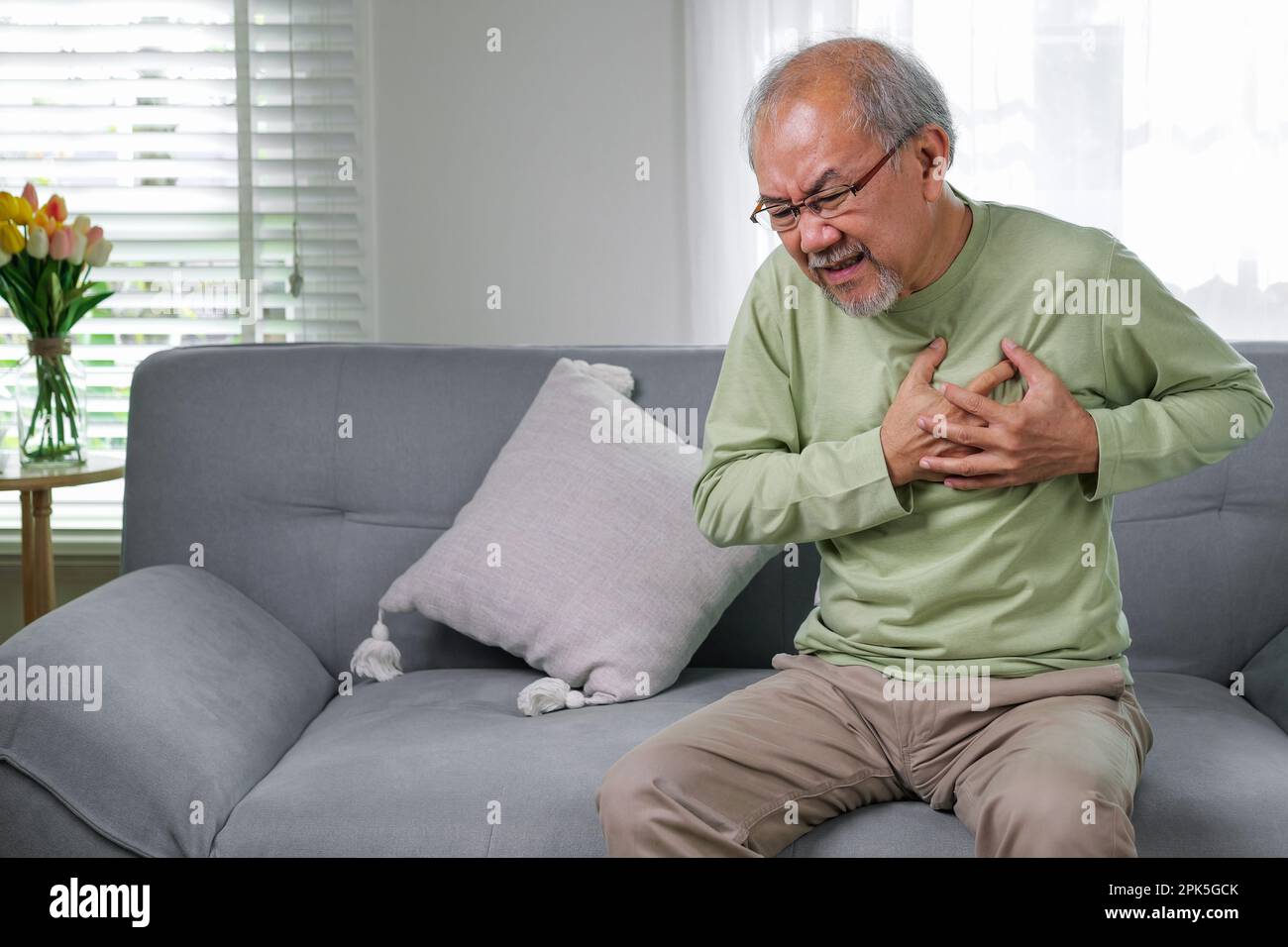 Heart attack symptoms, Senior heart attack suffering indoor Stock Photo - Alamy