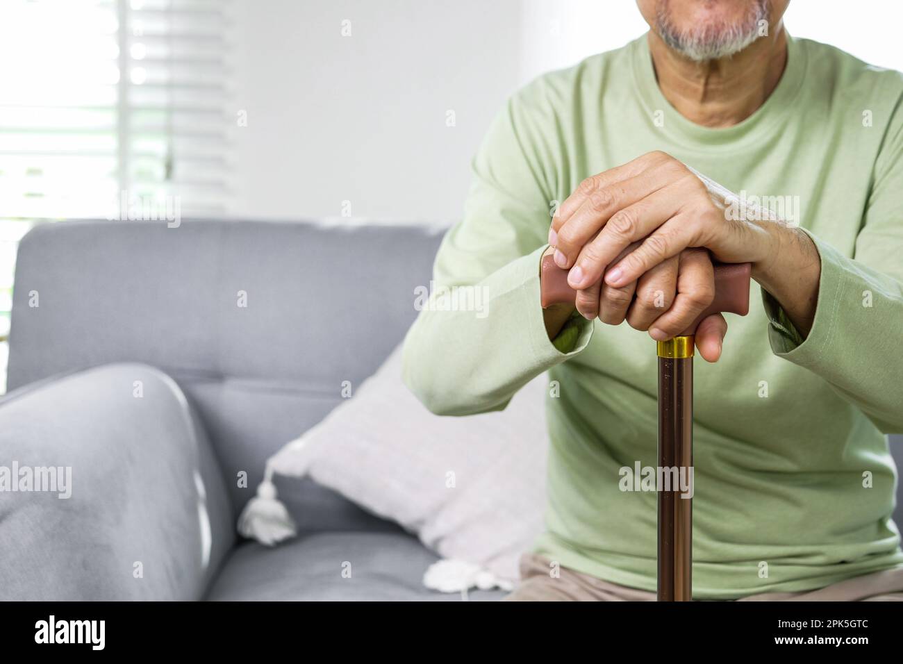 Close up hand of elderly man using walking stick trying to stand at ...