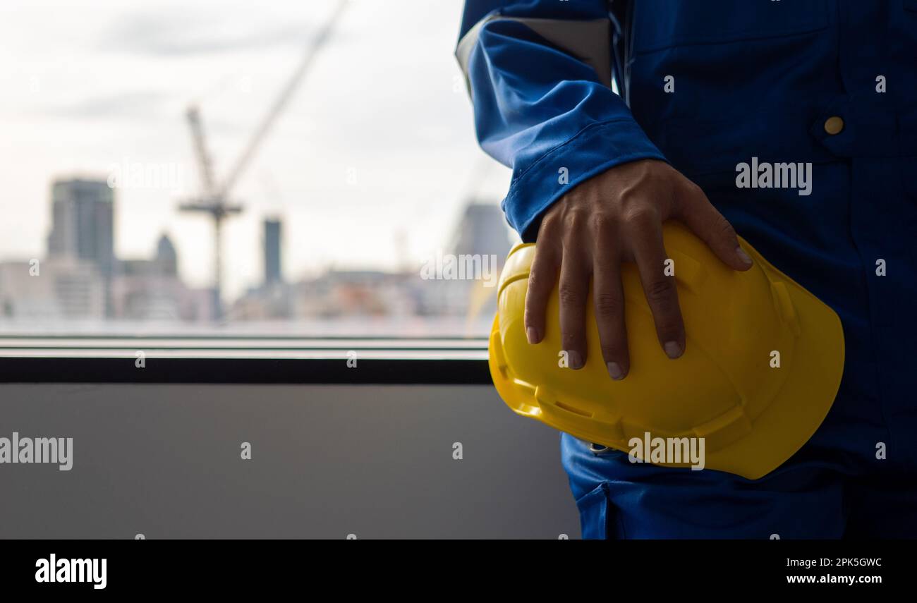 Engineer holding yellow helmet with construction building site ...