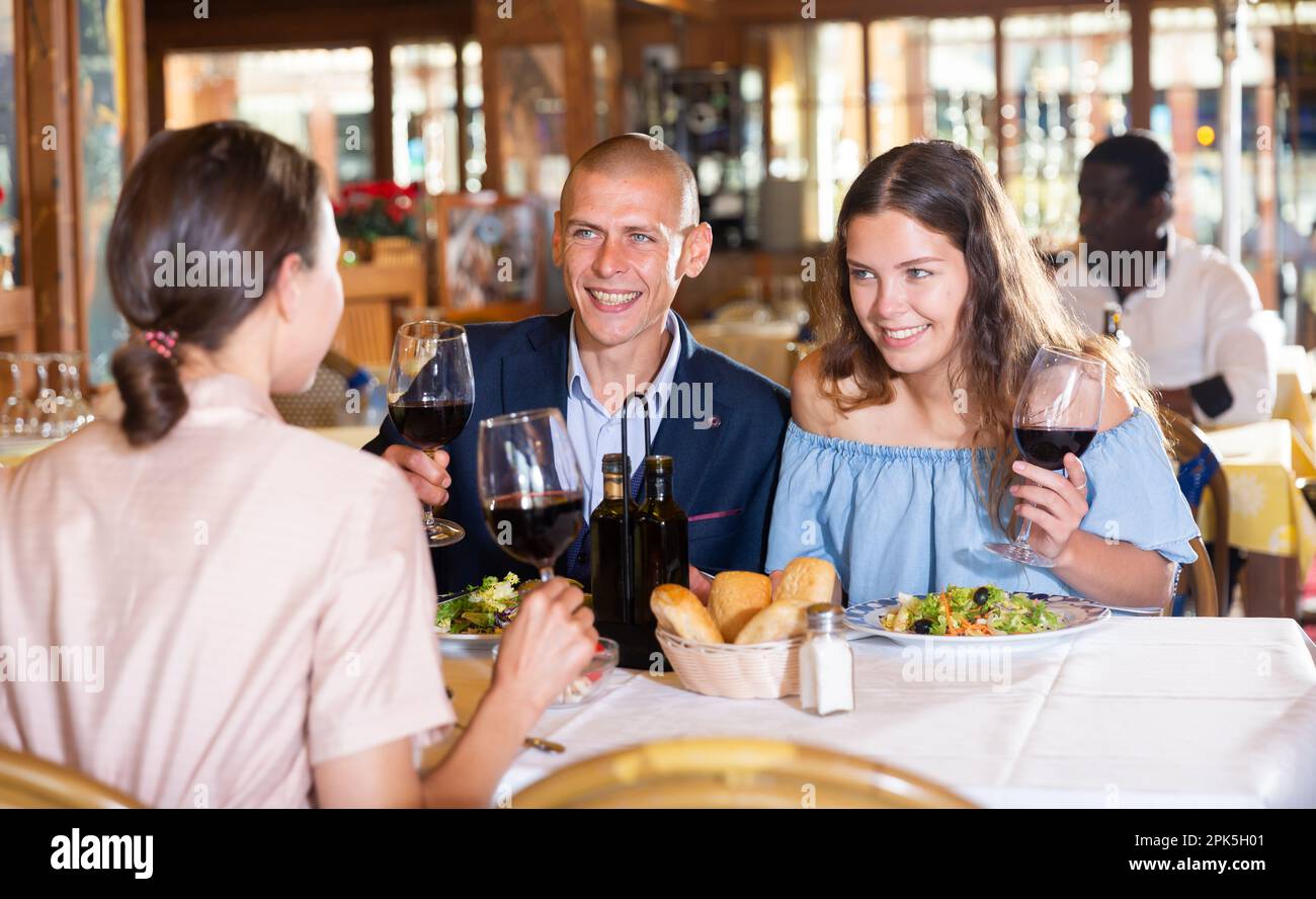Two cheerful couples having dinner and nice talking Stock Photo - Alamy