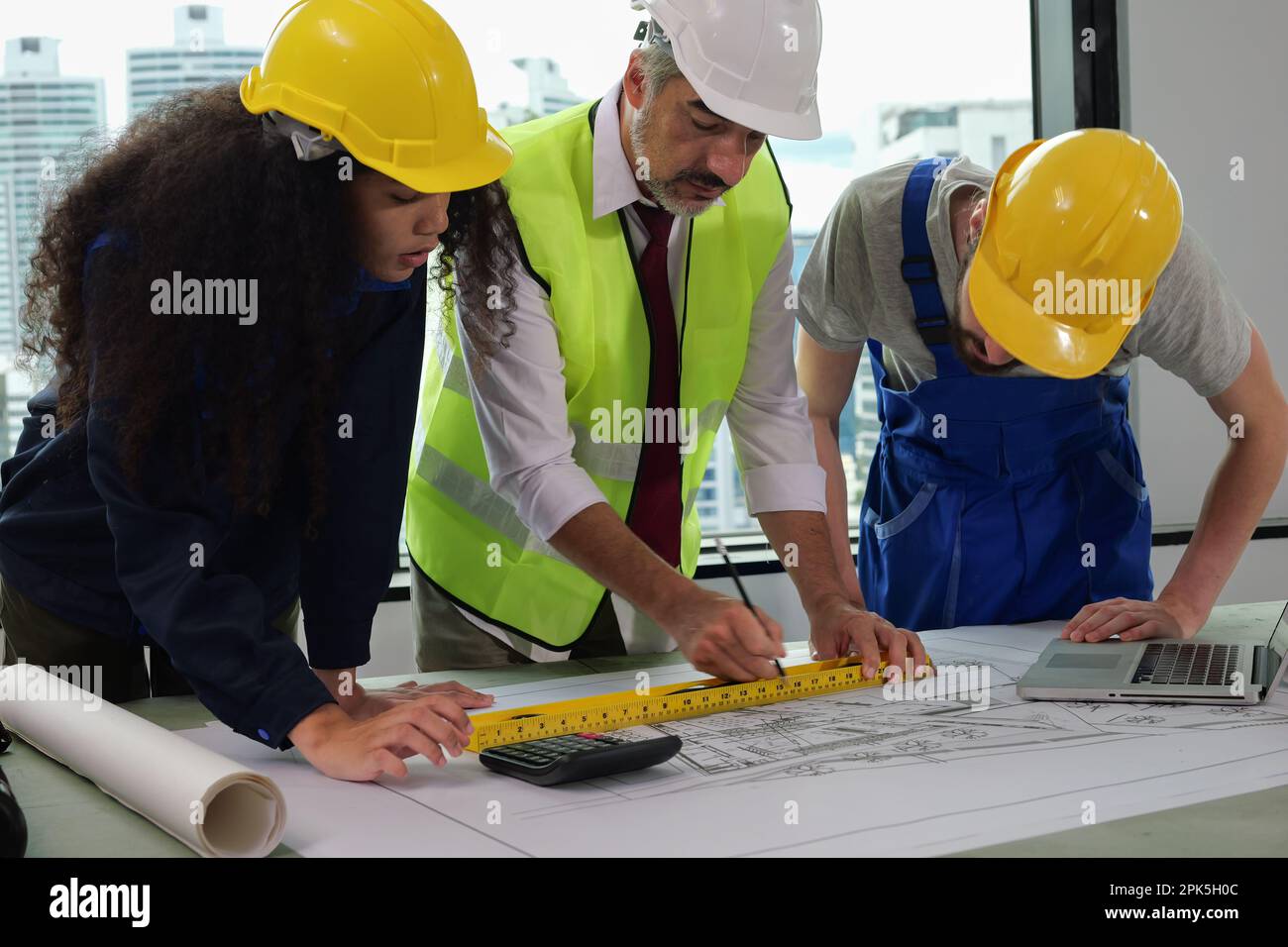 Professional construction engineers team using blueprint of project ...