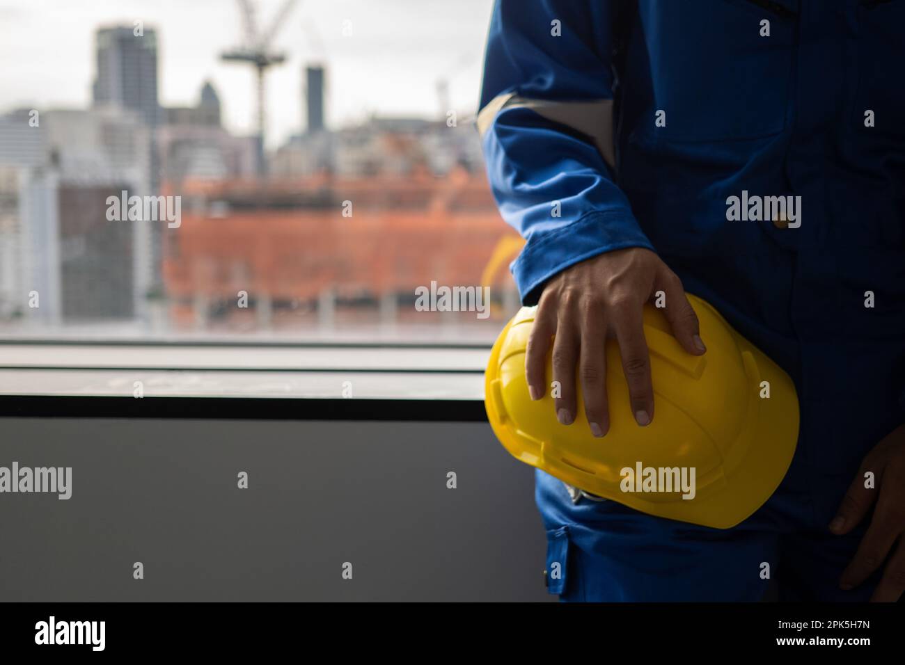 Engineer holding yellow helmet with construction building site ...