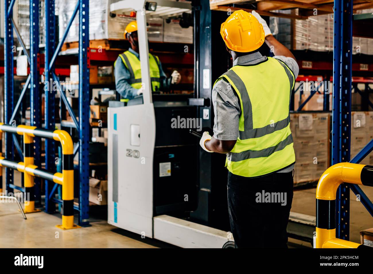 Professional warehouse worker moving cardboard boxes by forklift ...