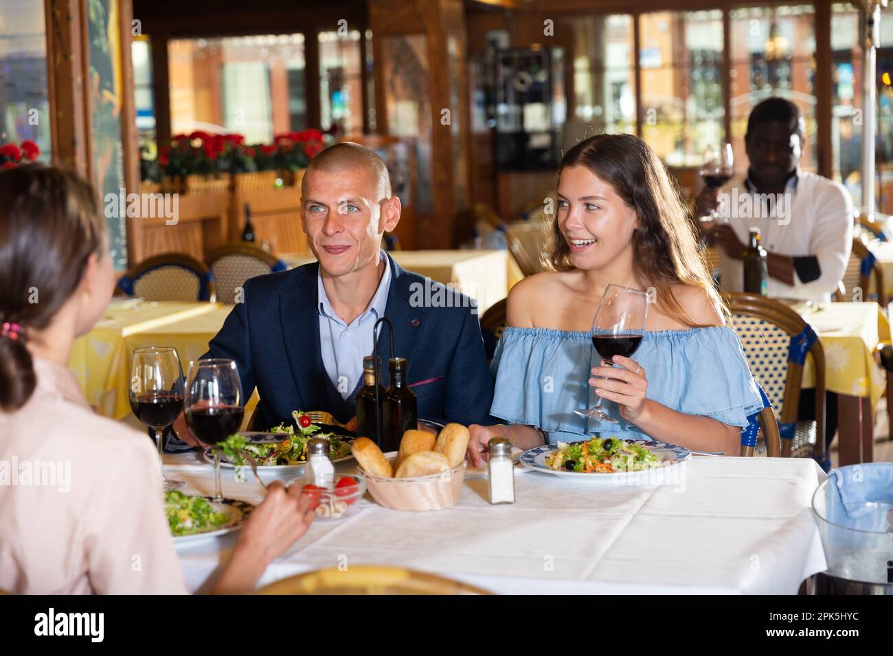 Company of smiling friends having dinner in restaurant Stock Photo - Alamy