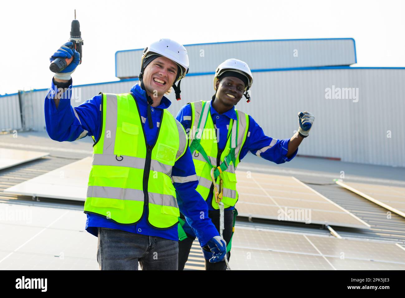 Happy engineers technicians installing solar panels on rooftop of plant ...
