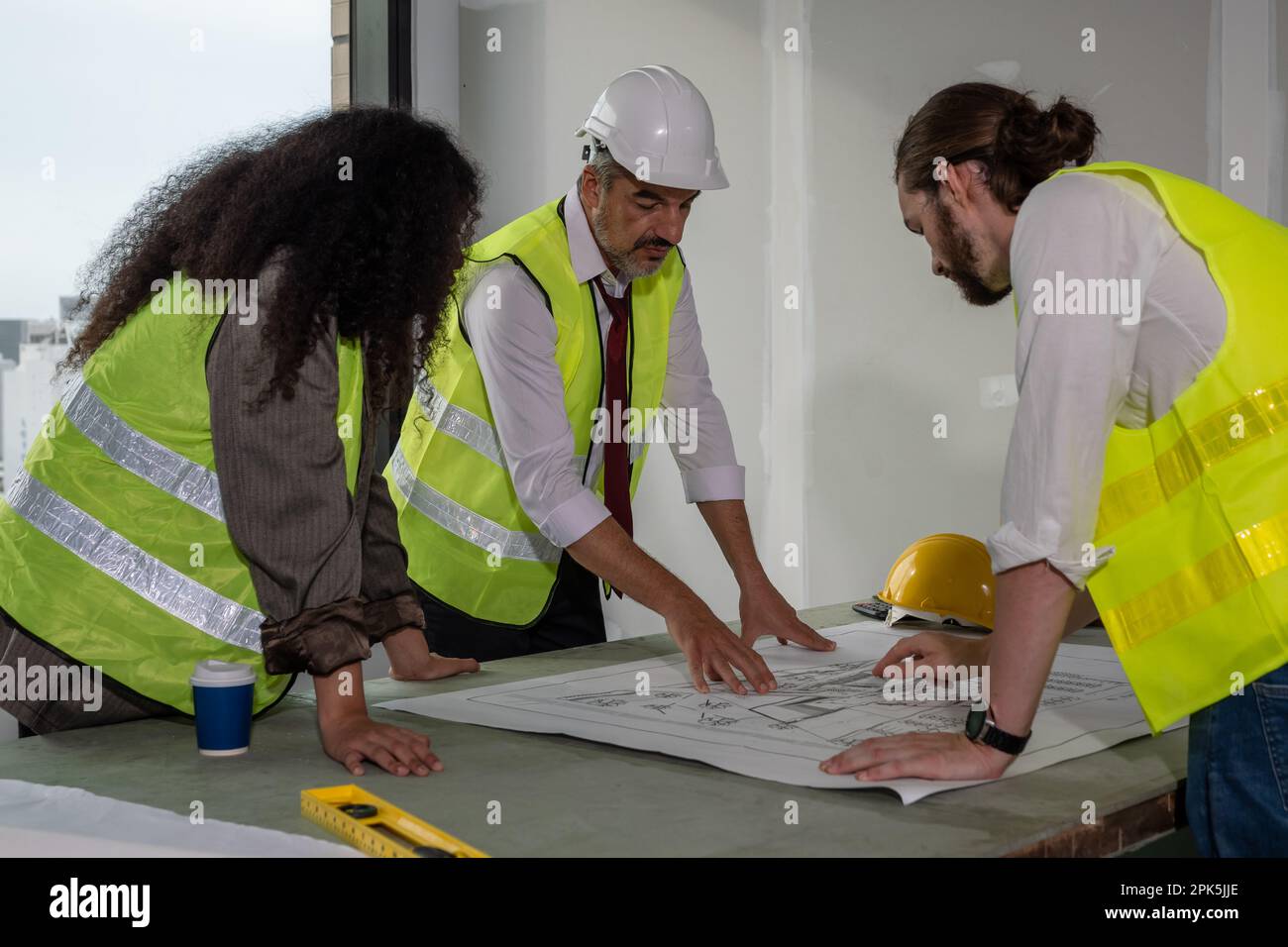 Professional construction engineers team using blueprint of project ...