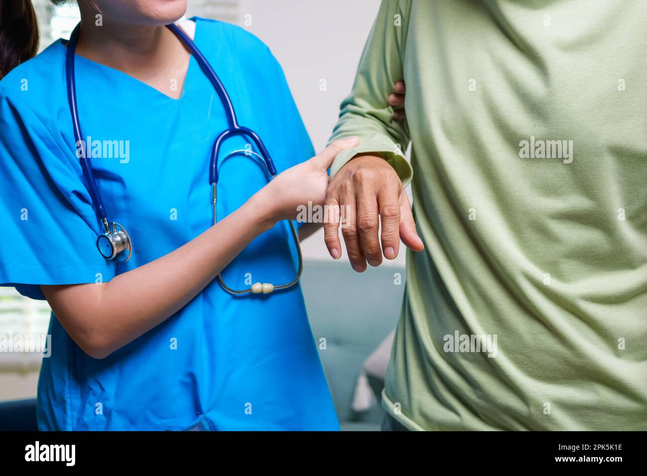 Elderly patient on sofa trying to stand and walking with caregiver nurse Stock Photo - Alamy