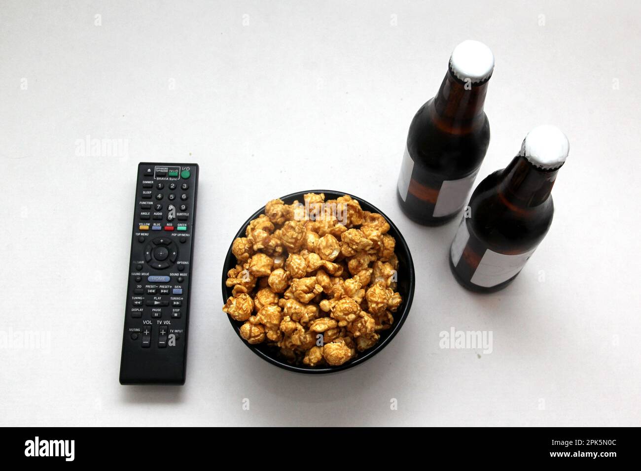 Freshly made caramel popcorn in a container accompanied by drinks and ...