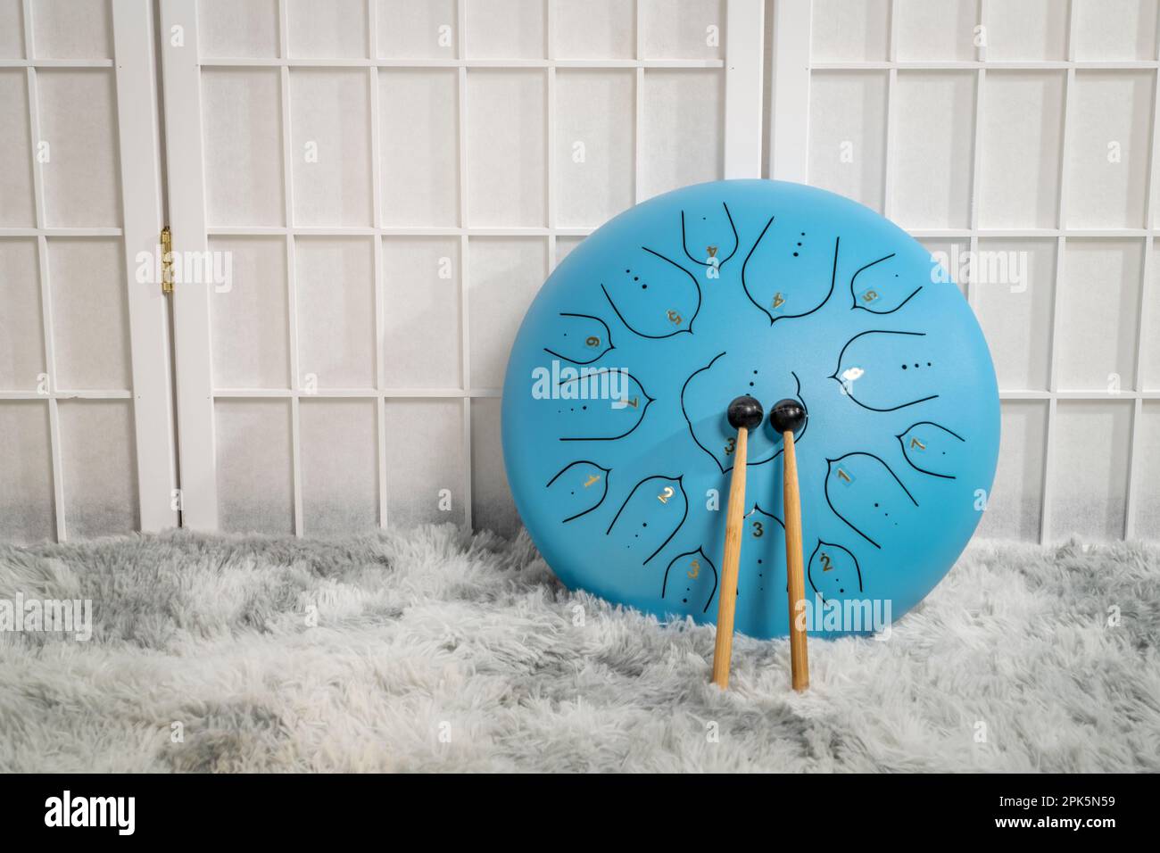 blue steel tongue drum with mallets on a fluffy rug Stock Photo - Alamy