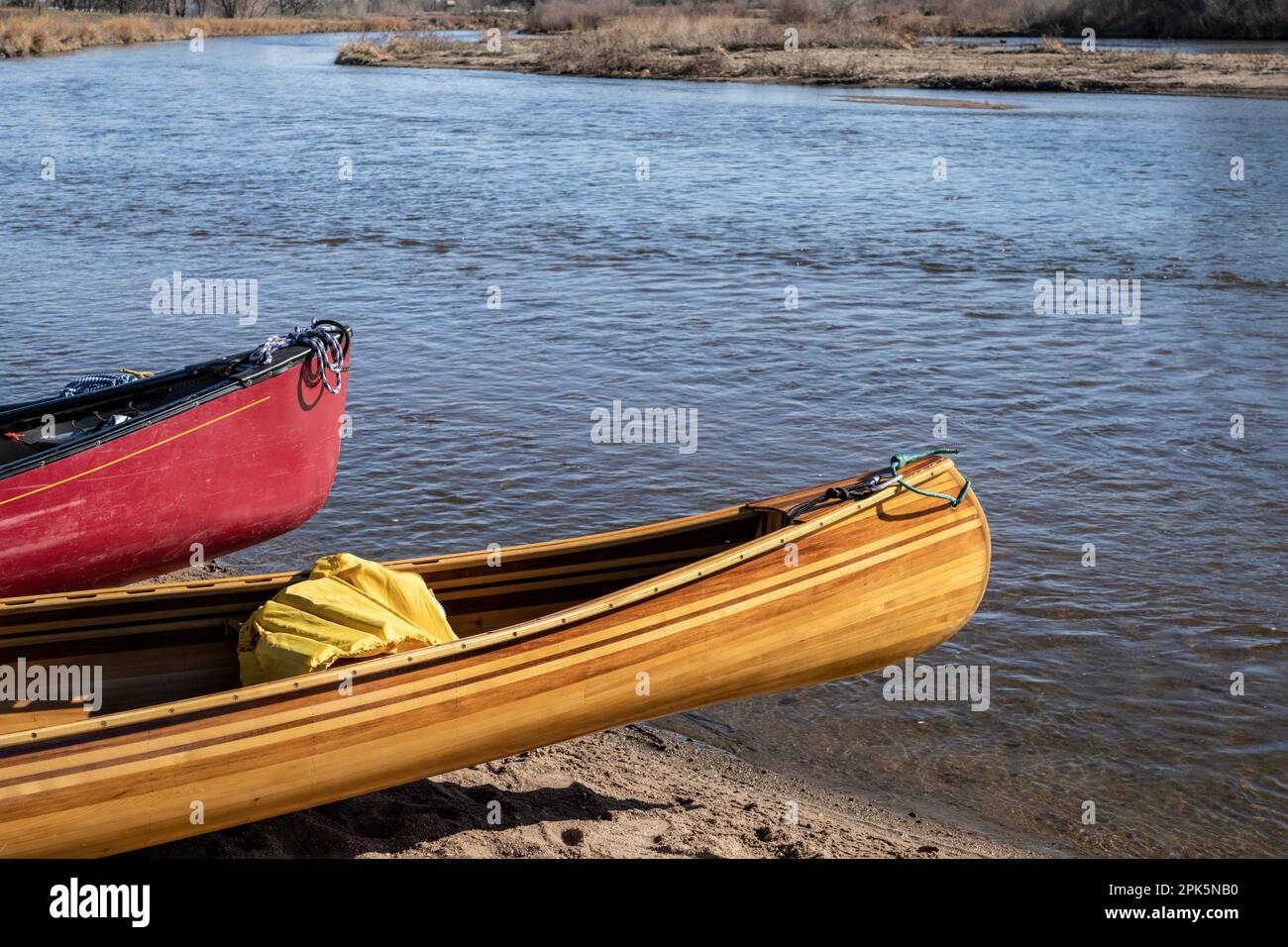 a bow of beautiful, home built, wooden canoe on a river shore Stock ...