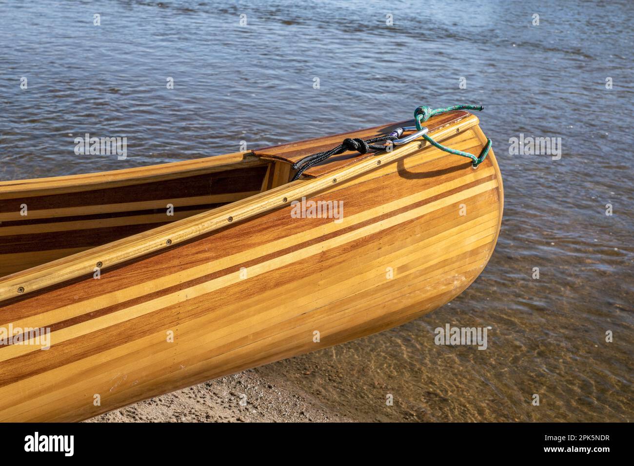 a bow of beautiful, home built, wooden canoe on a river shore Stock ...