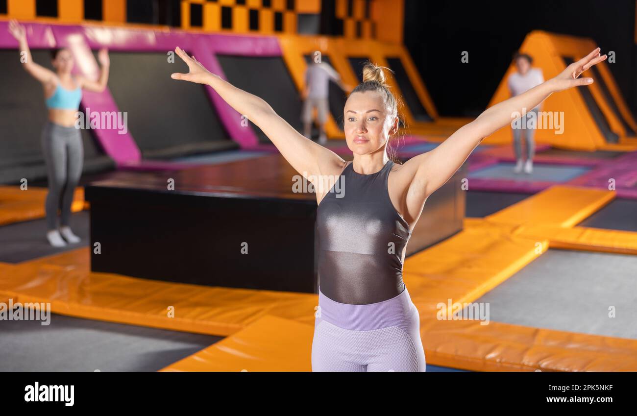 Adult woman trains jumping in trampoline center Stock Photo - Alamy