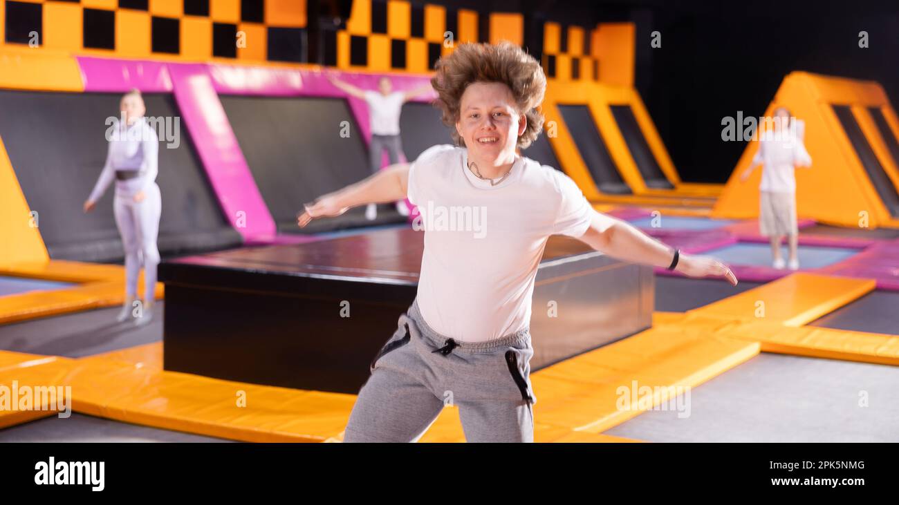 Teenage boy in sport clothes high jumping in trampoline arena Stock ...