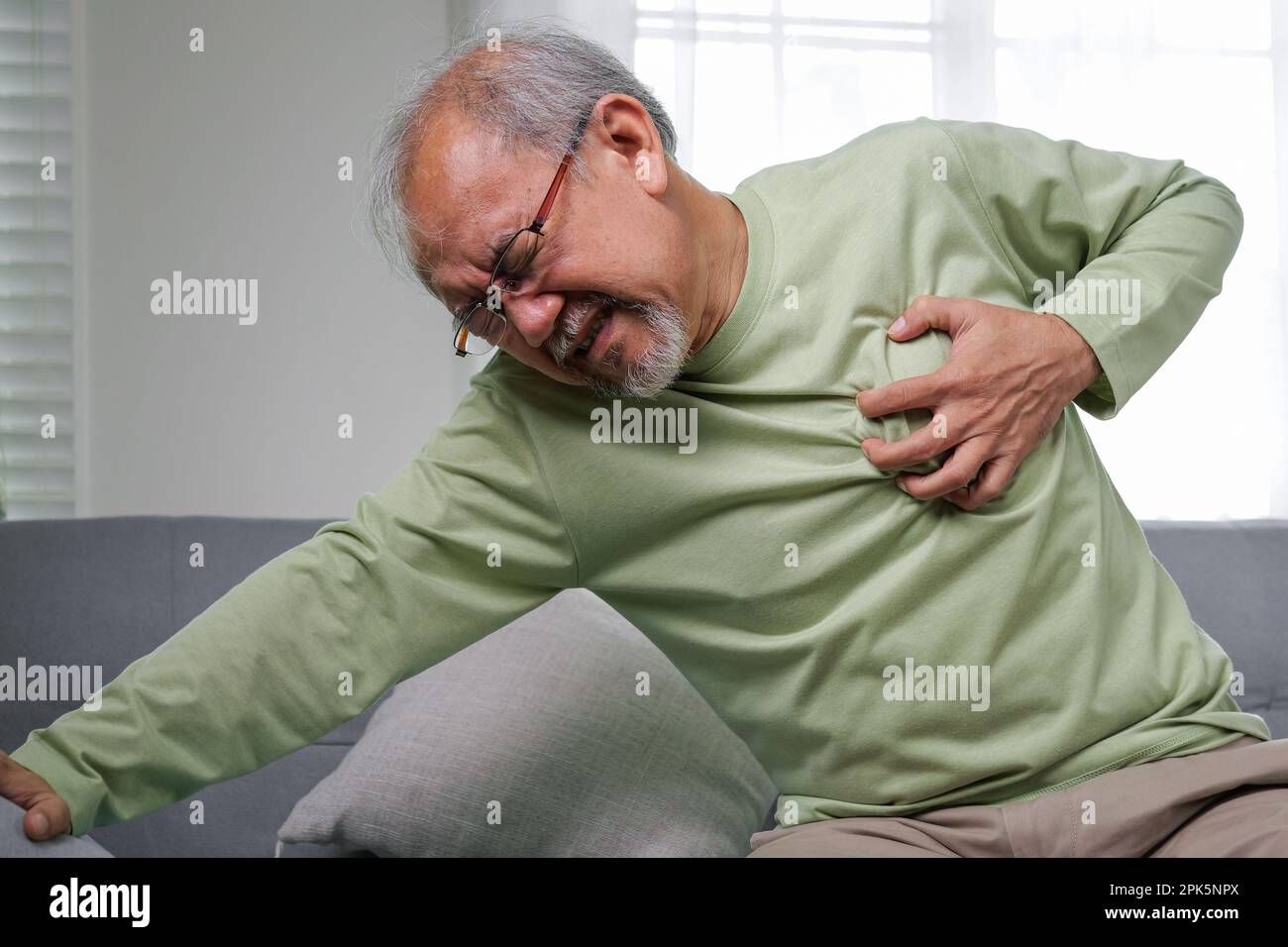 Heart attack symptoms, Senior heart attack suffering indoor Stock Photo ...