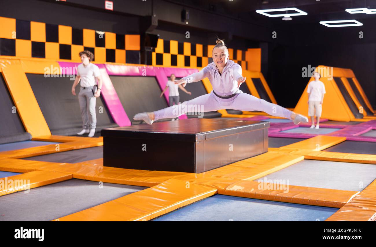 Adult woman trains jumping in trampoline center Stock Photo - Alamy