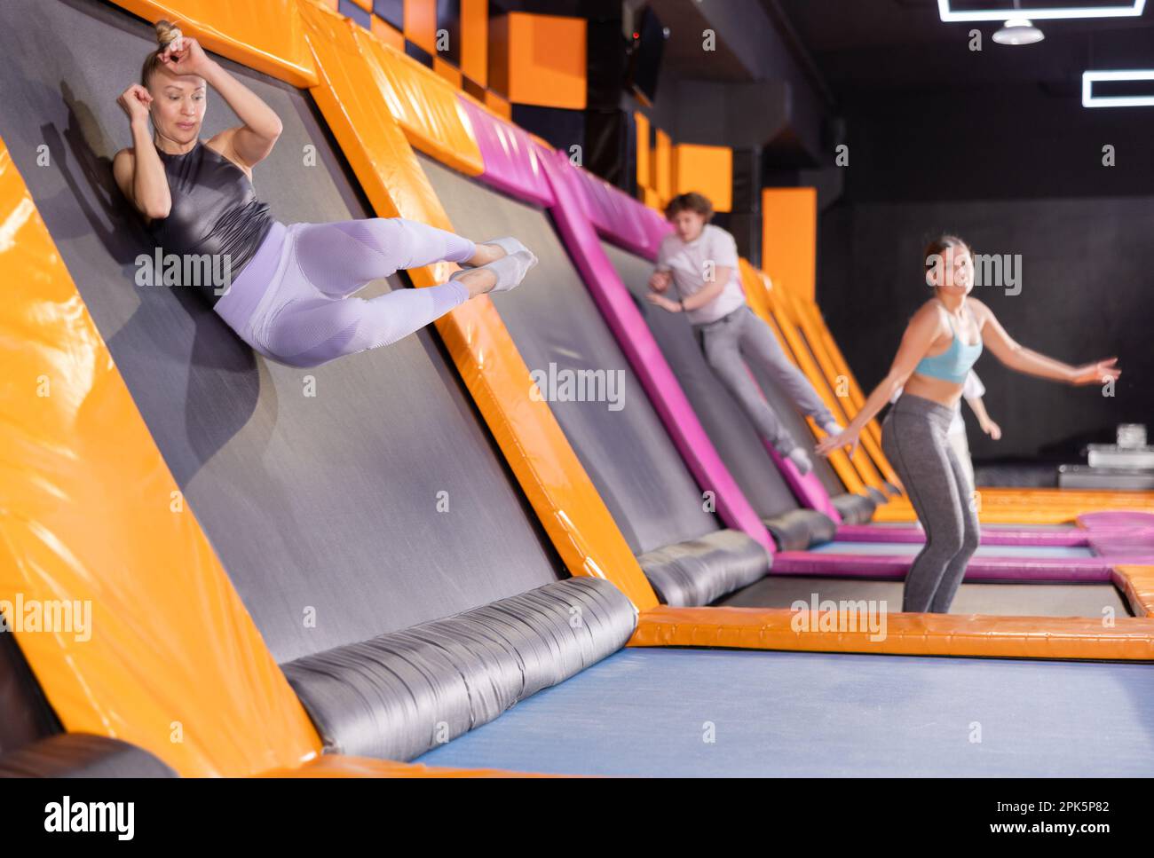 Adult woman trains jumping in trampoline center Stock Photo - Alamy