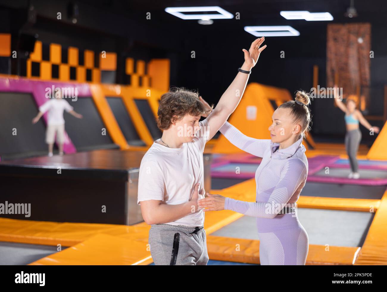 Young guy and adult woman in training for trampolining Stock Photo - Alamy