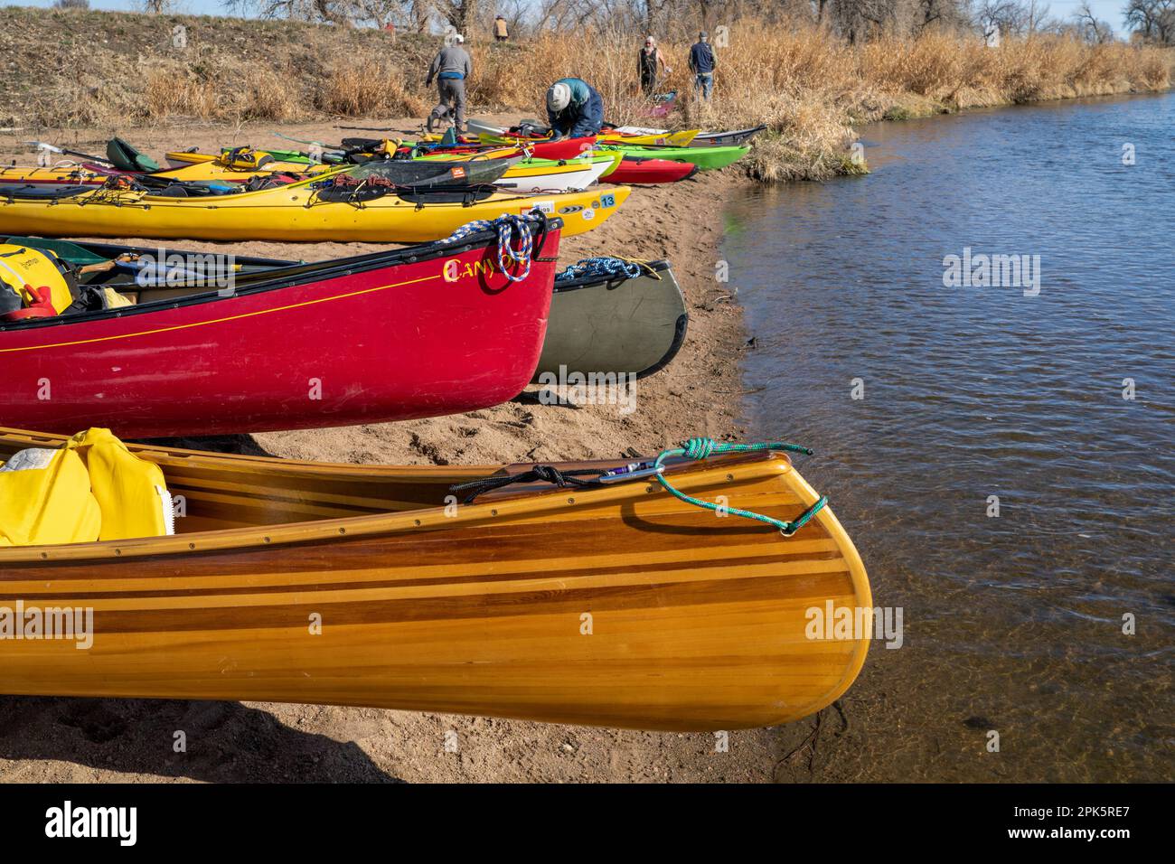 Evans, CO, USA - April 1, 2023: Canoes and kayaks lined up on a beach ...