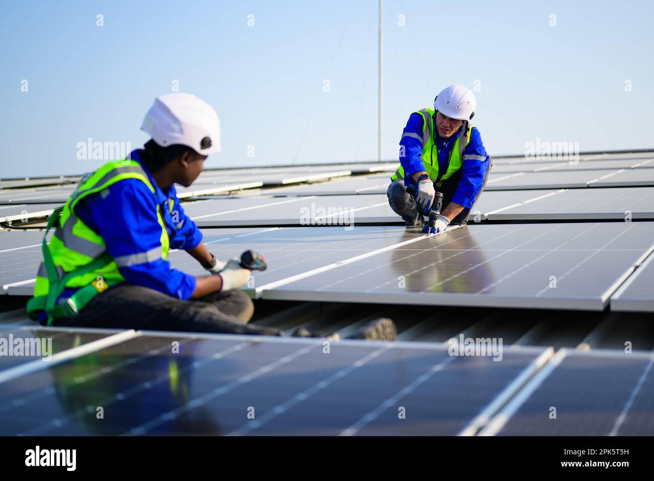 Professional technicians installing solar panels on rooftop of plant ...