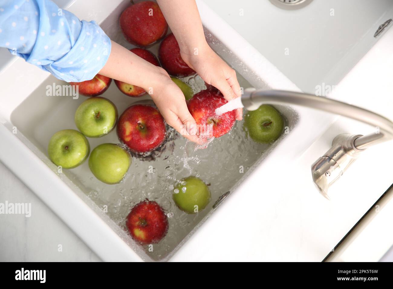 Woman washing fresh apples in kitchen sink, top view Stock Photo - Alamy